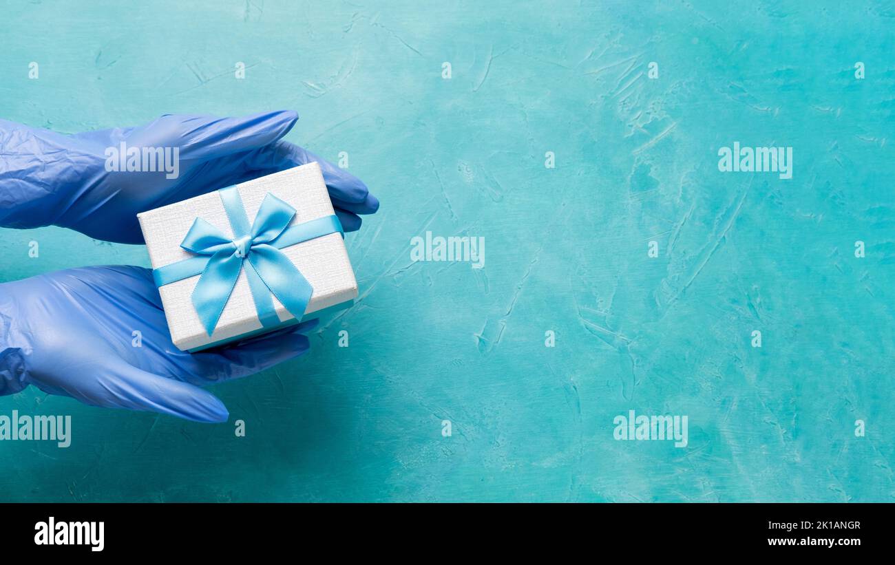 Safety delivery. Holiday surprise. Hands in medicine gloves holding ...