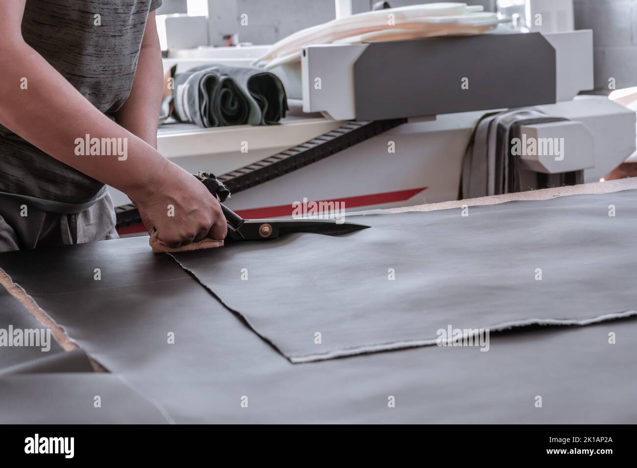 A cutter cuts fabric with scissors in a sewing workshop Stock Photo - Alamy