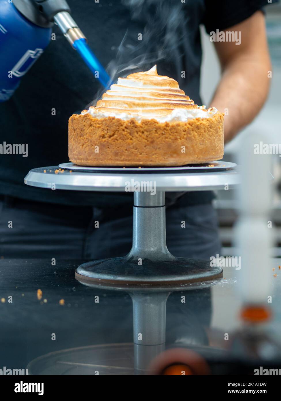 baker using a pastry burner flame torch on a meringue cake Stock Photo ...