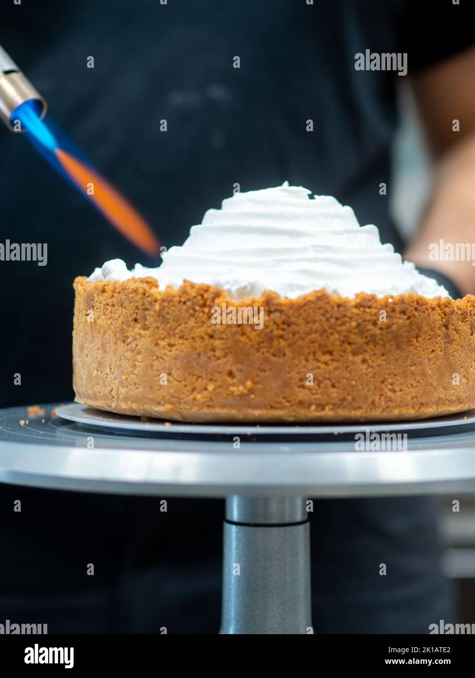 baker using a pastry burner flame torch on a meringue cake Stock Photo ...