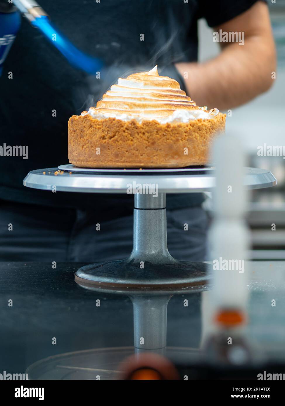 baker using a pastry burner flame torch on a meringue cake Stock Photo ...
