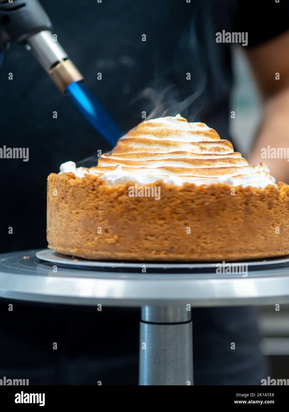 baker using a pastry burner flame torch on a meringue cake Stock Photo ...