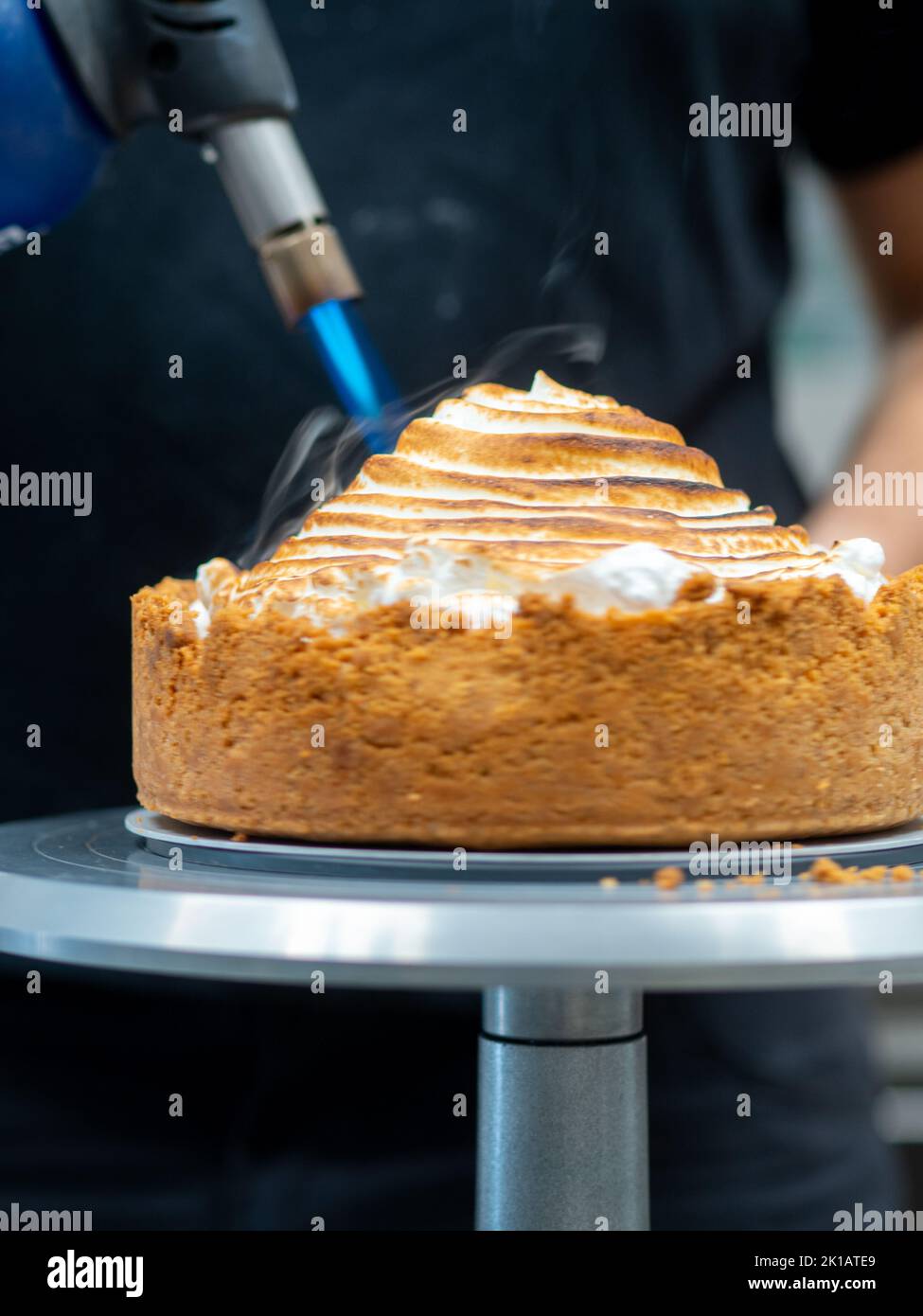 baker using a pastry burner flame torch on a meringue cake Stock Photo ...