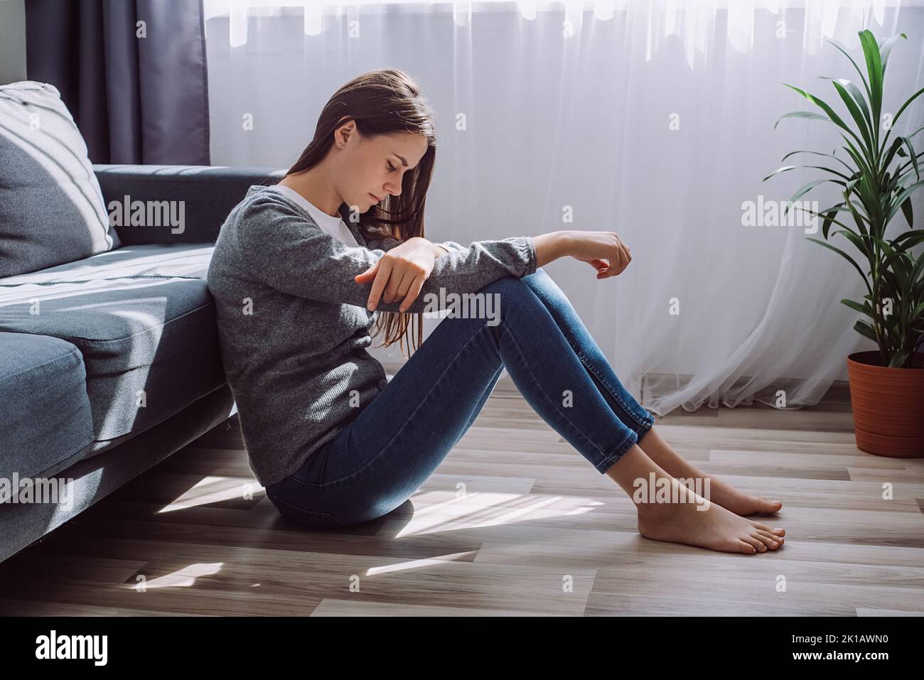 Depressed sad worried young brunette woman sitting on floor alone ...
