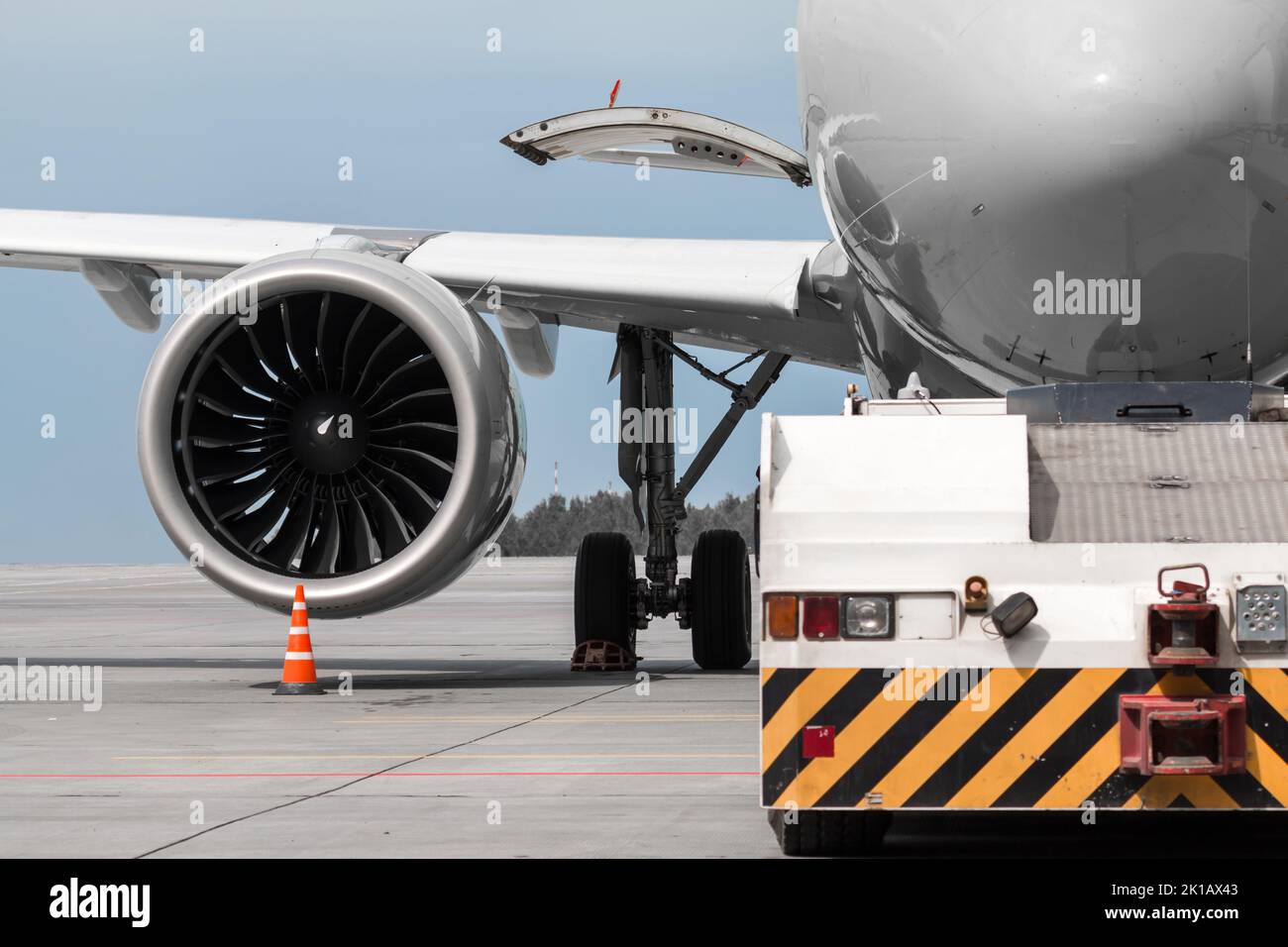 Close-up tow truck near the passenger airplane. Close-up of engine and ...
