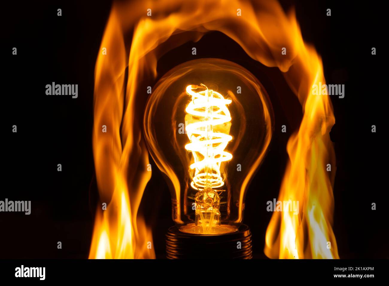 A light bulb with fire flames around it on a black background Stock ...