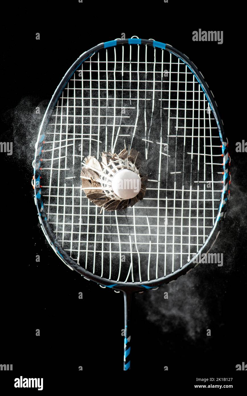 Badminton racket in motion, shuttlecock in action, black background ...