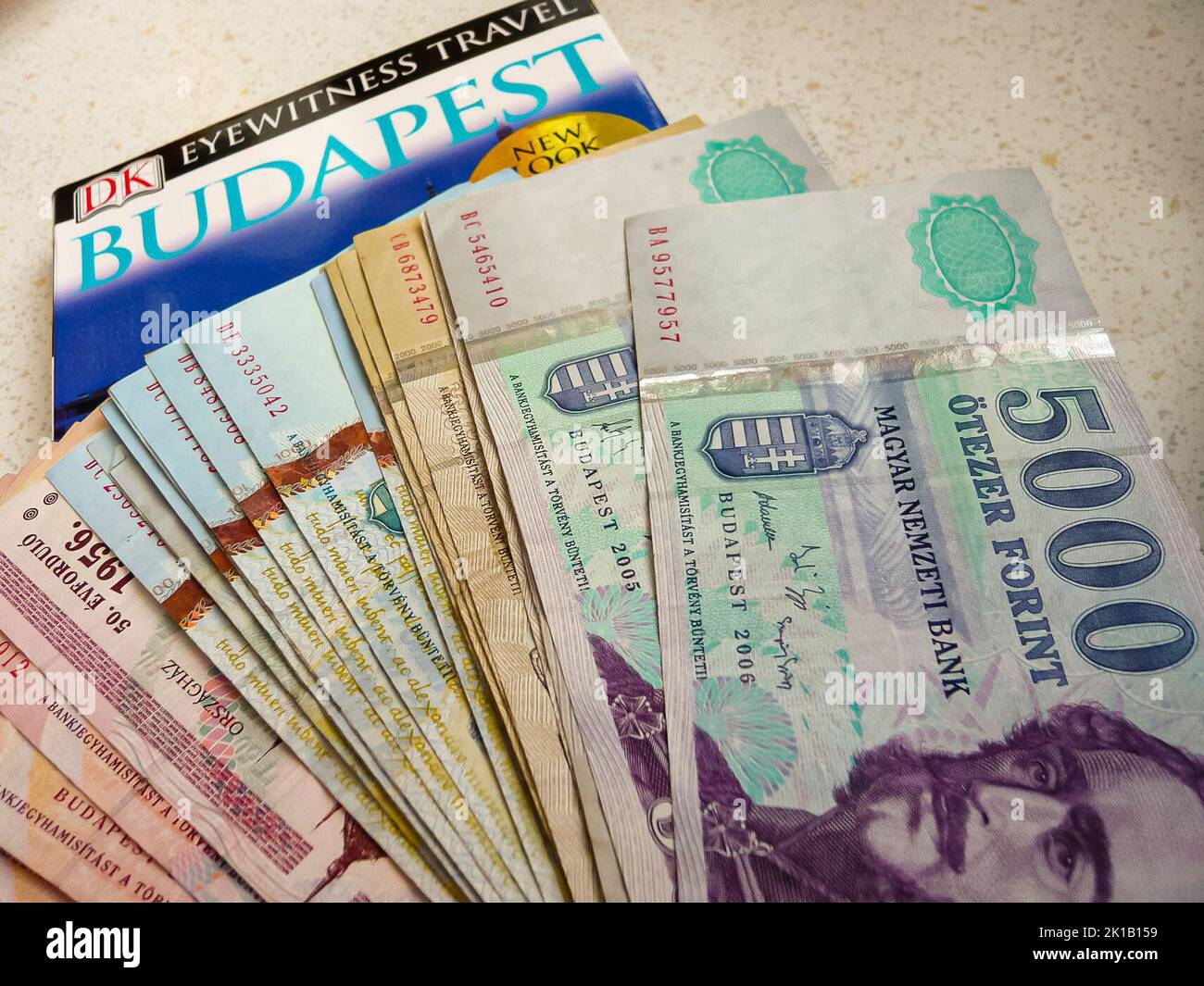 Pile of Forint, the currency used in Hungary, with a guide book for ...