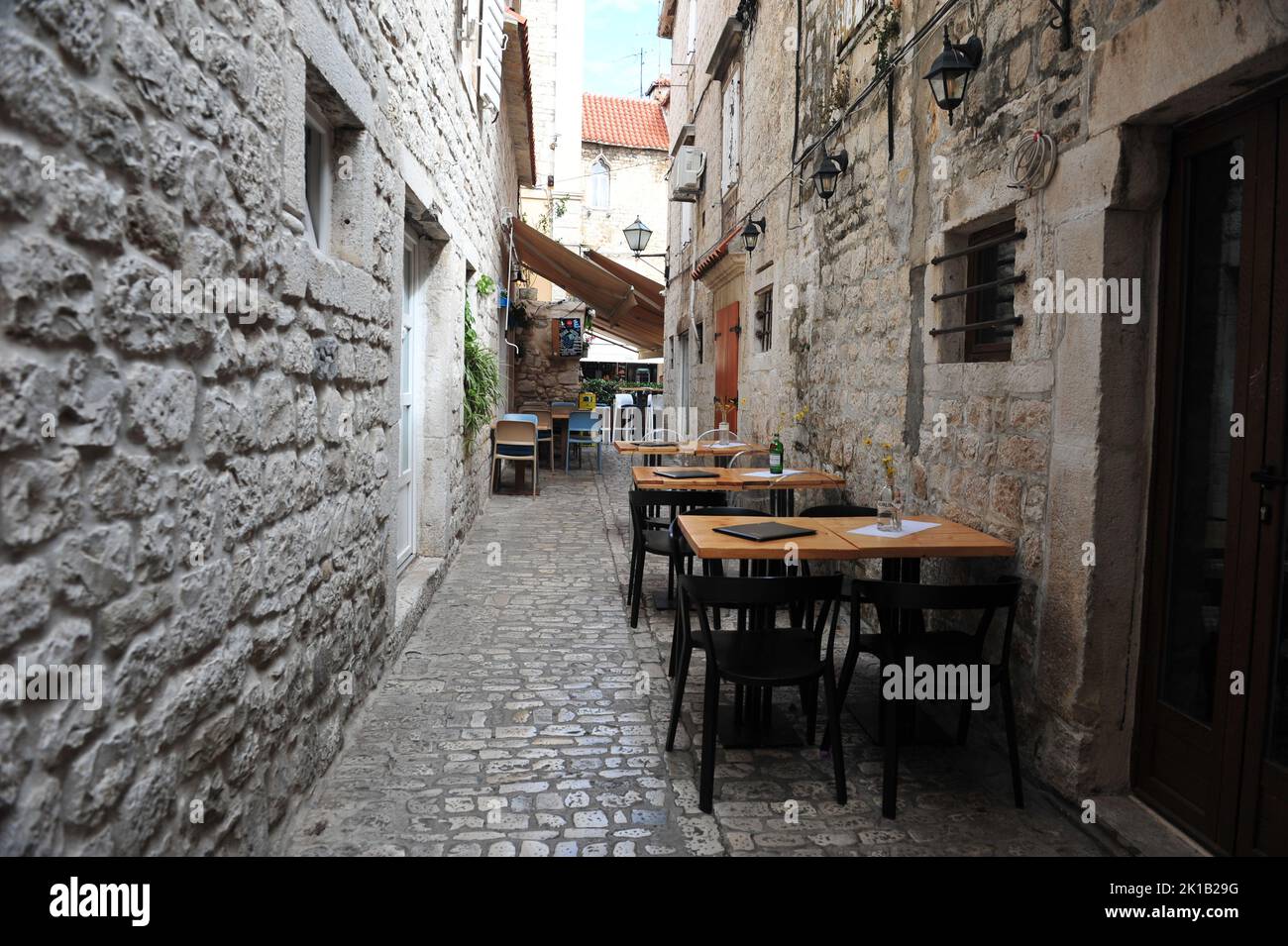 Tiny restaurant in secluded narrow back alley in Trogir, Croatia. Empty ...