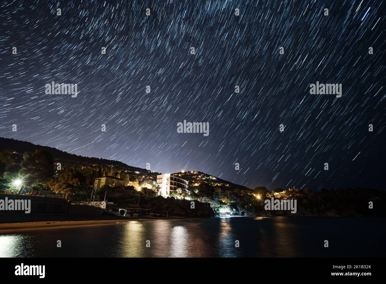 A dramatic scenery of meteor shower in the night sky above the city ...