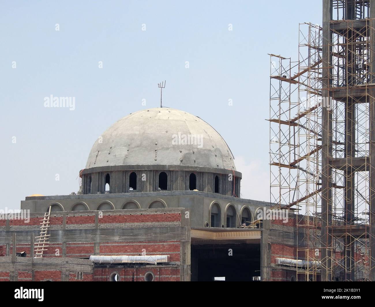 A new mosque under construction against the sunny blue sky with the ...