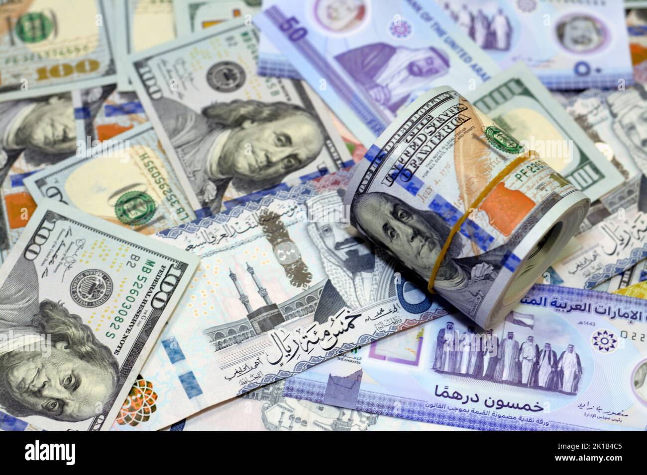 American money roll with a band on a pile of American dollar bills ...