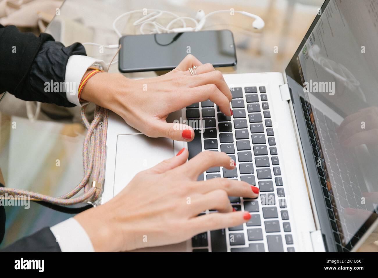 Side view crop hands of anonymous female in formal black suit typing on ...