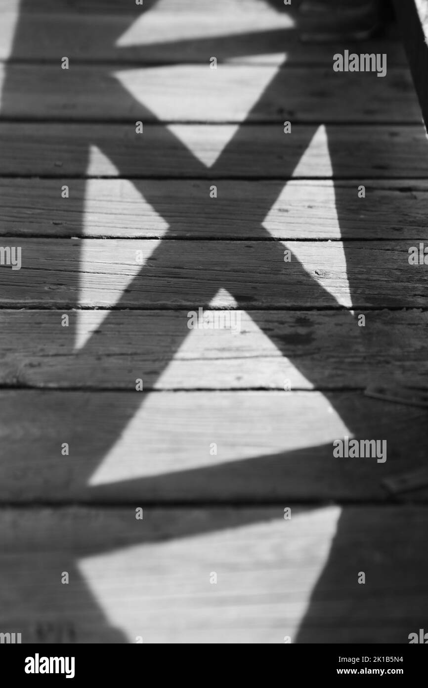 A vertical grayscale shot of shadows resembling the letter X or cross ...