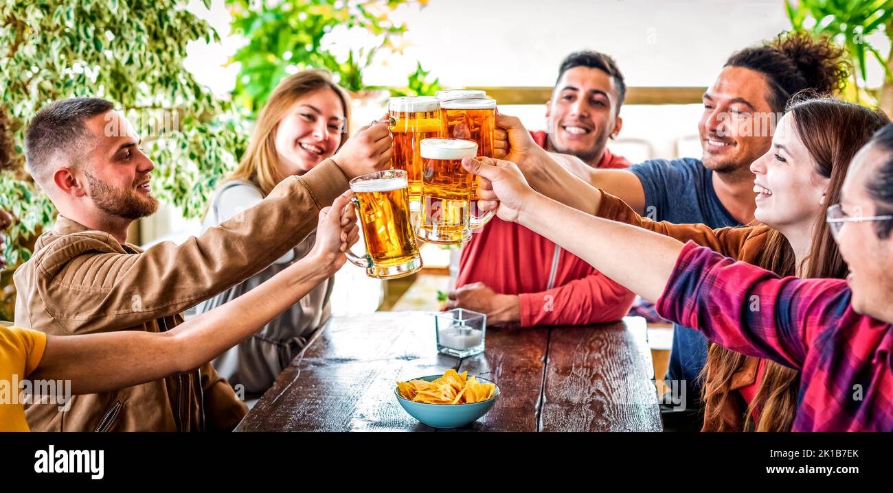 happy weekend. group of friends cheering clincking beer glasses in a ...