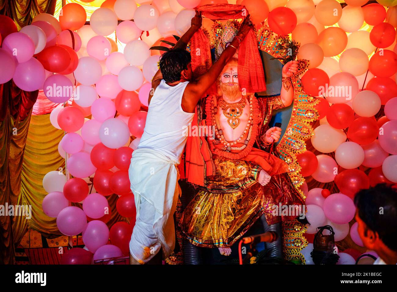 A priest offering prayers on the idol of Lord Vishwakarma during ...