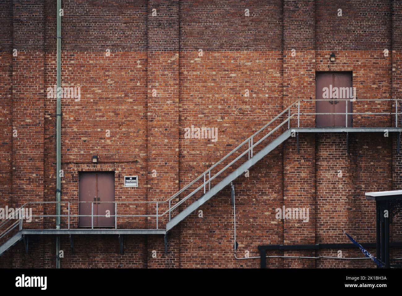 A wall with two pink doors being connected by a bridge Stock Photo - Alamy
