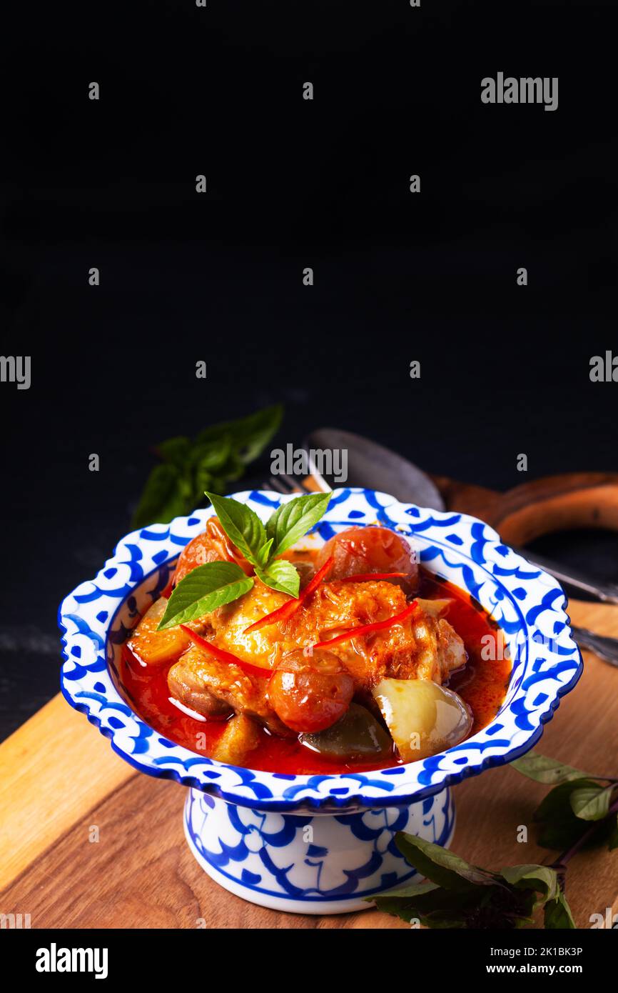 Thai Food concept Roasted chicken red curry on wooden board on black ...