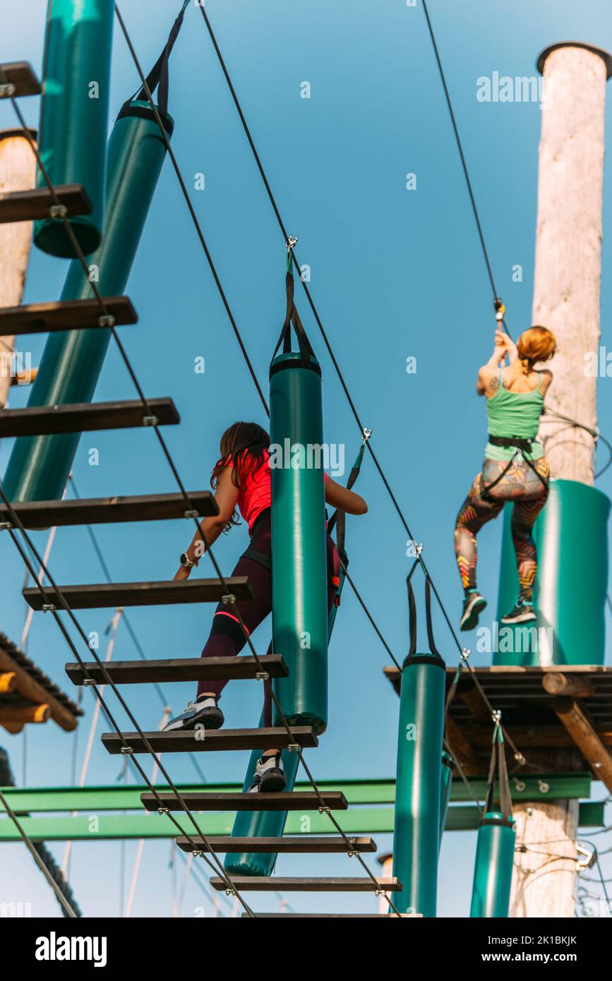 Athletic young woman going down a zip line in the adventure park Stock ...