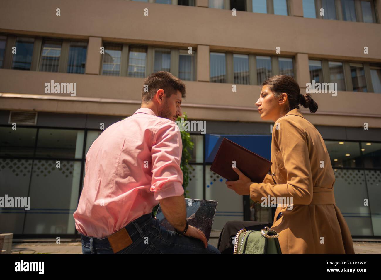 A tired business friends are having a great time after work, sitting on ...