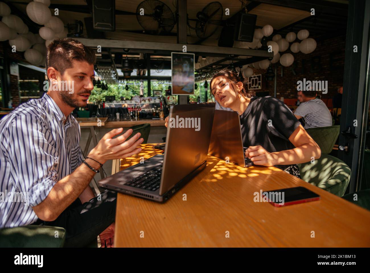 A young beautiful businesswoman is trying to help to her male colleague ...