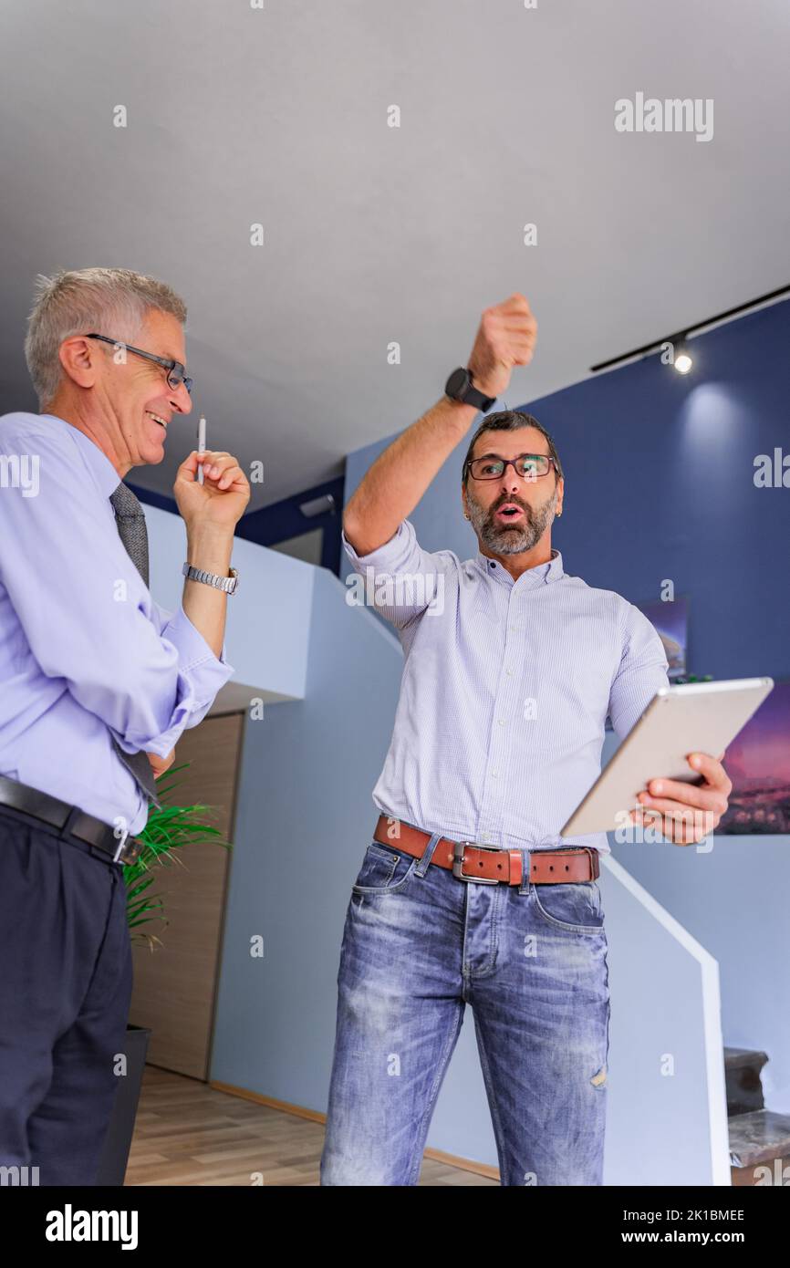 Two senior businessmen are talking and standing together Stock Photo ...