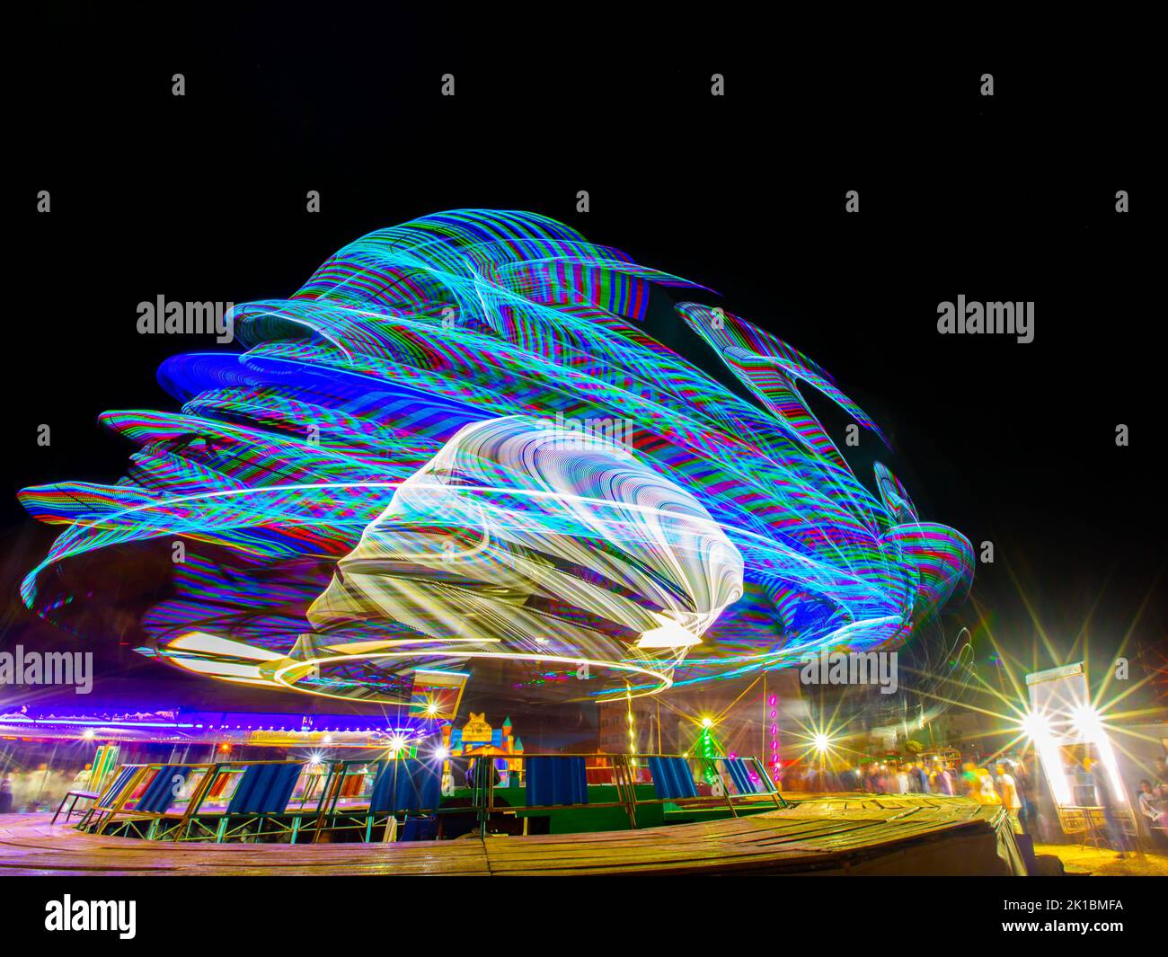 Moving light from ferris wheel at night Stock Photo - Alamy