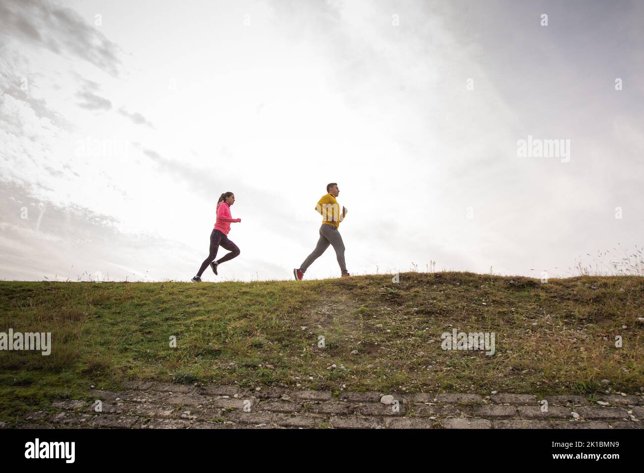 Amazing and beautiful strong couple is running together while enjoying ...