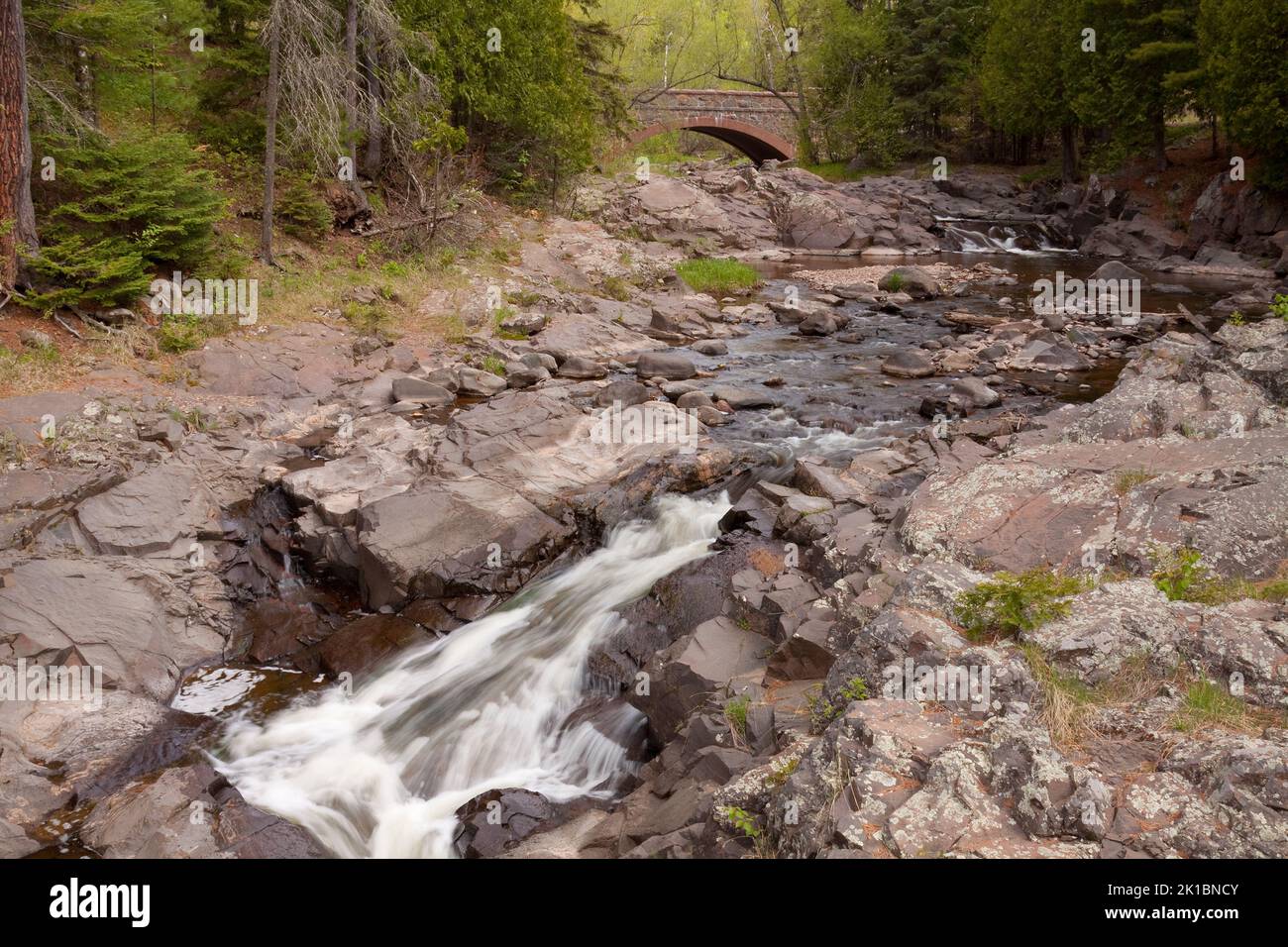 A Stone Arch Bridge and Cascading Waterfall On Amity Creek Stock Photo ...
