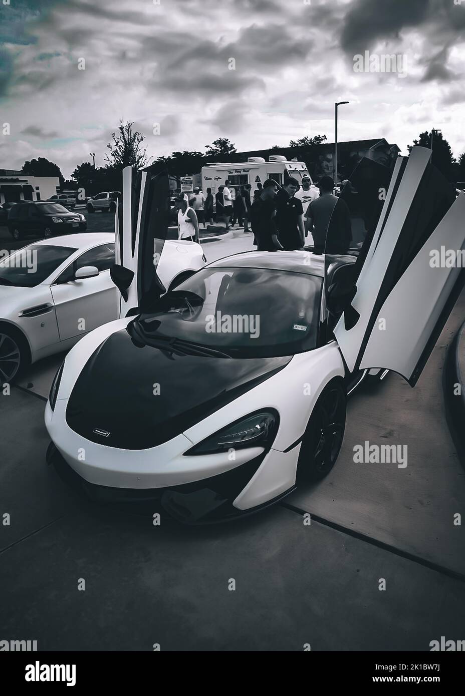 A vertical black and white shot of a McLaren luxury car on the street ...