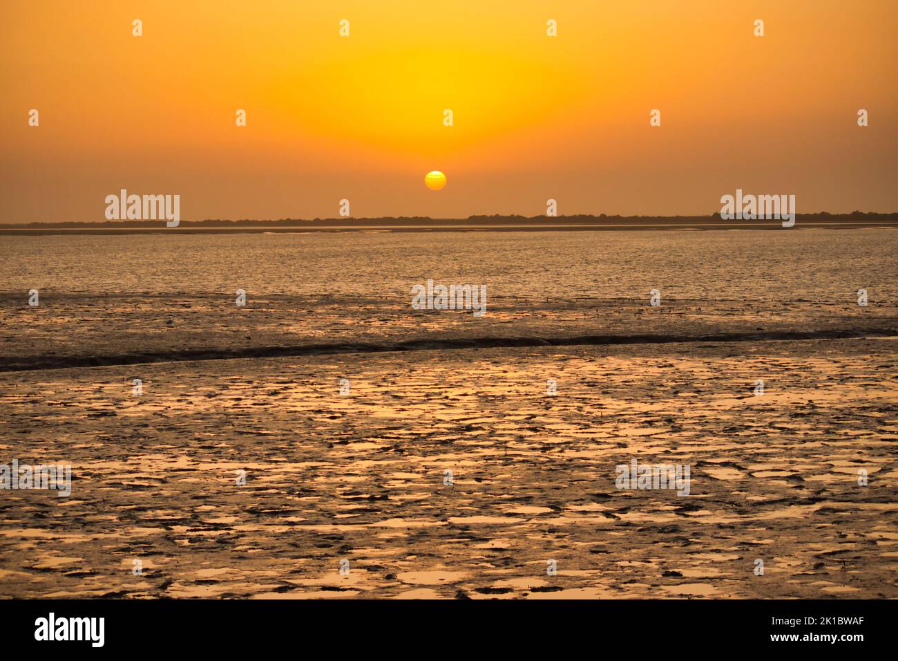 A dramatic scenery of a vibrant sunset over the ocean on the horizon ...