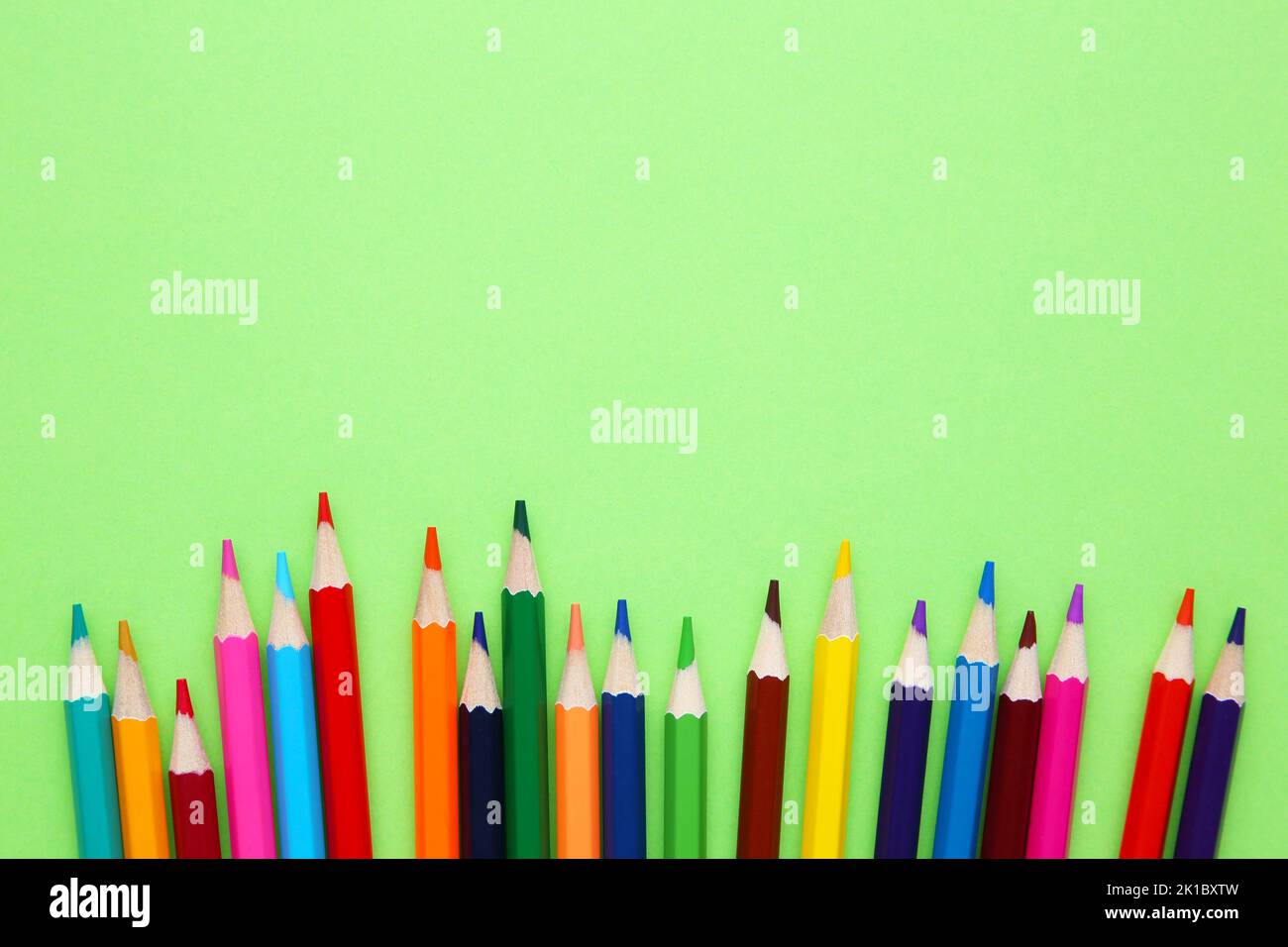 Many different colored pencils on lime background Stock Photo - Alamy
