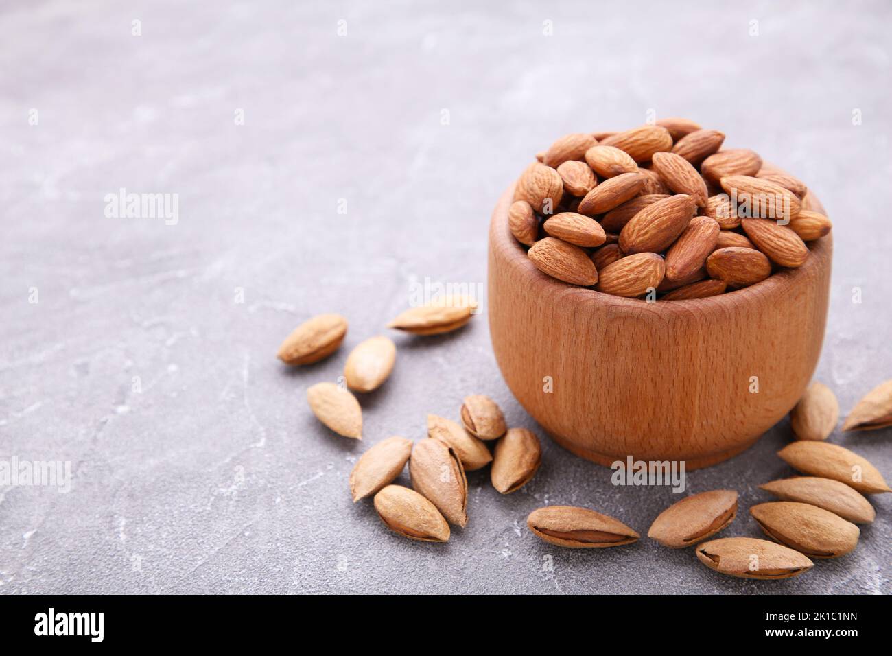 Wooden bowl of almonds on a blue background Stock Photo - Alamy