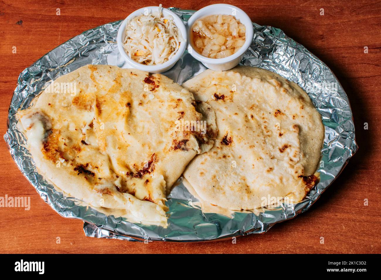 Top view of two Nicaraguan pupusas served with salad on the table ...