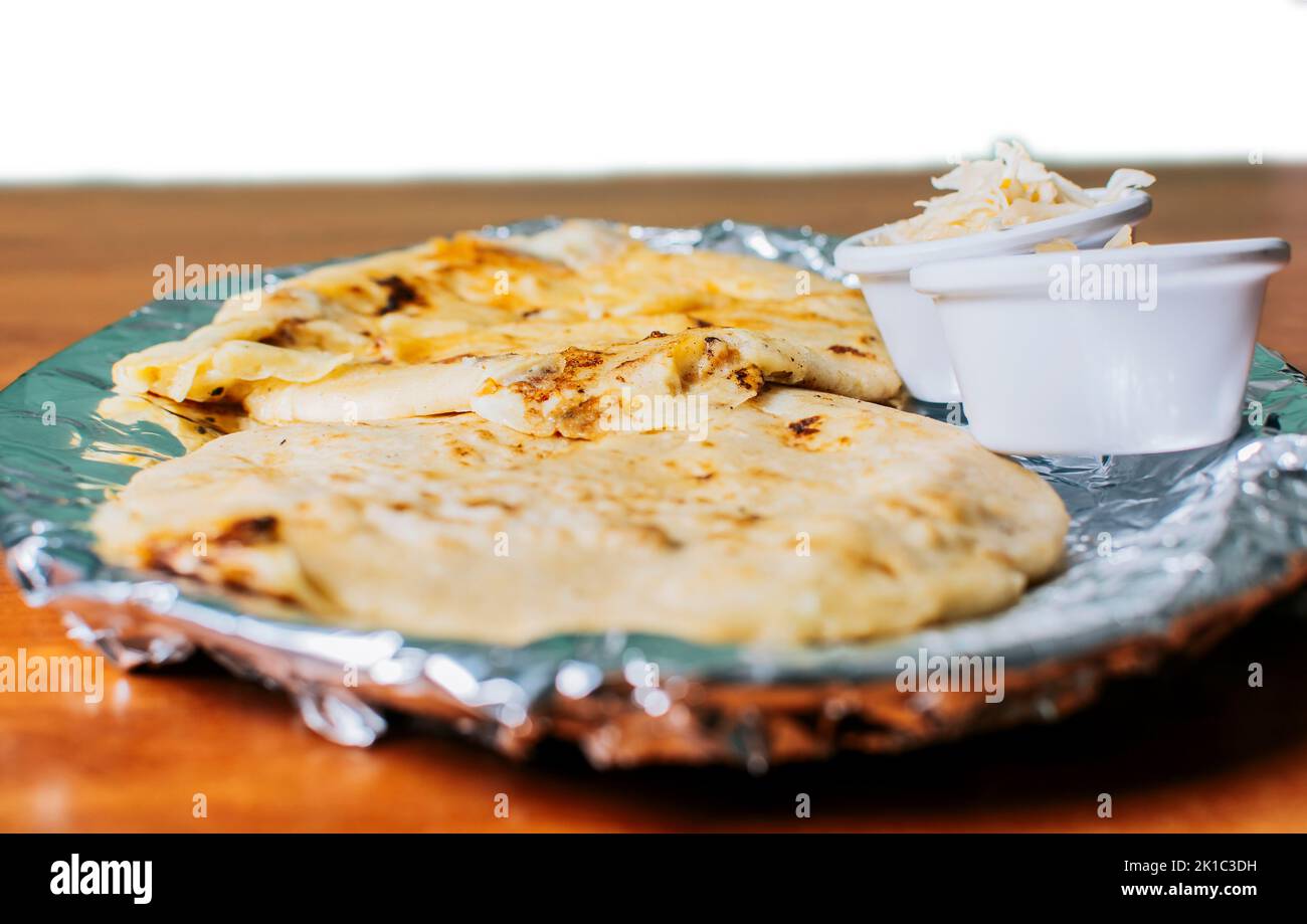 Traditional pupusas served with salad on the table. Two Nicaraguan ...