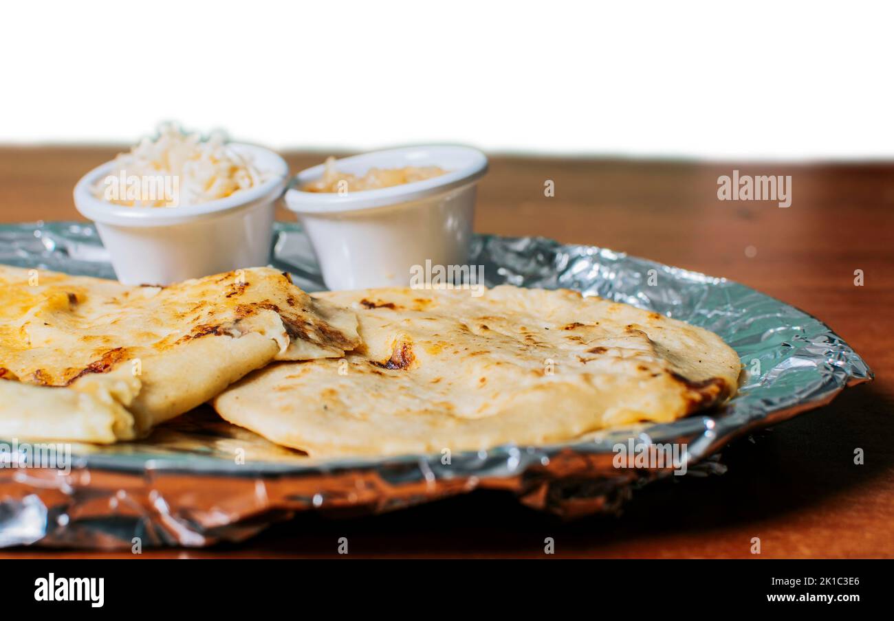 Two traditional pupusas served with salad on the table. Two Nicaraguan ...