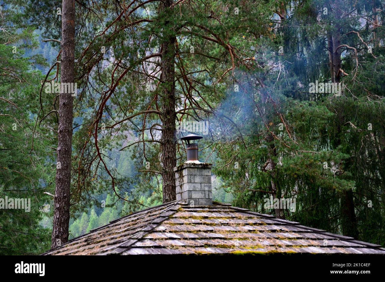 Smoke comes out of the chimney on the roof of the barbecue structure in ...