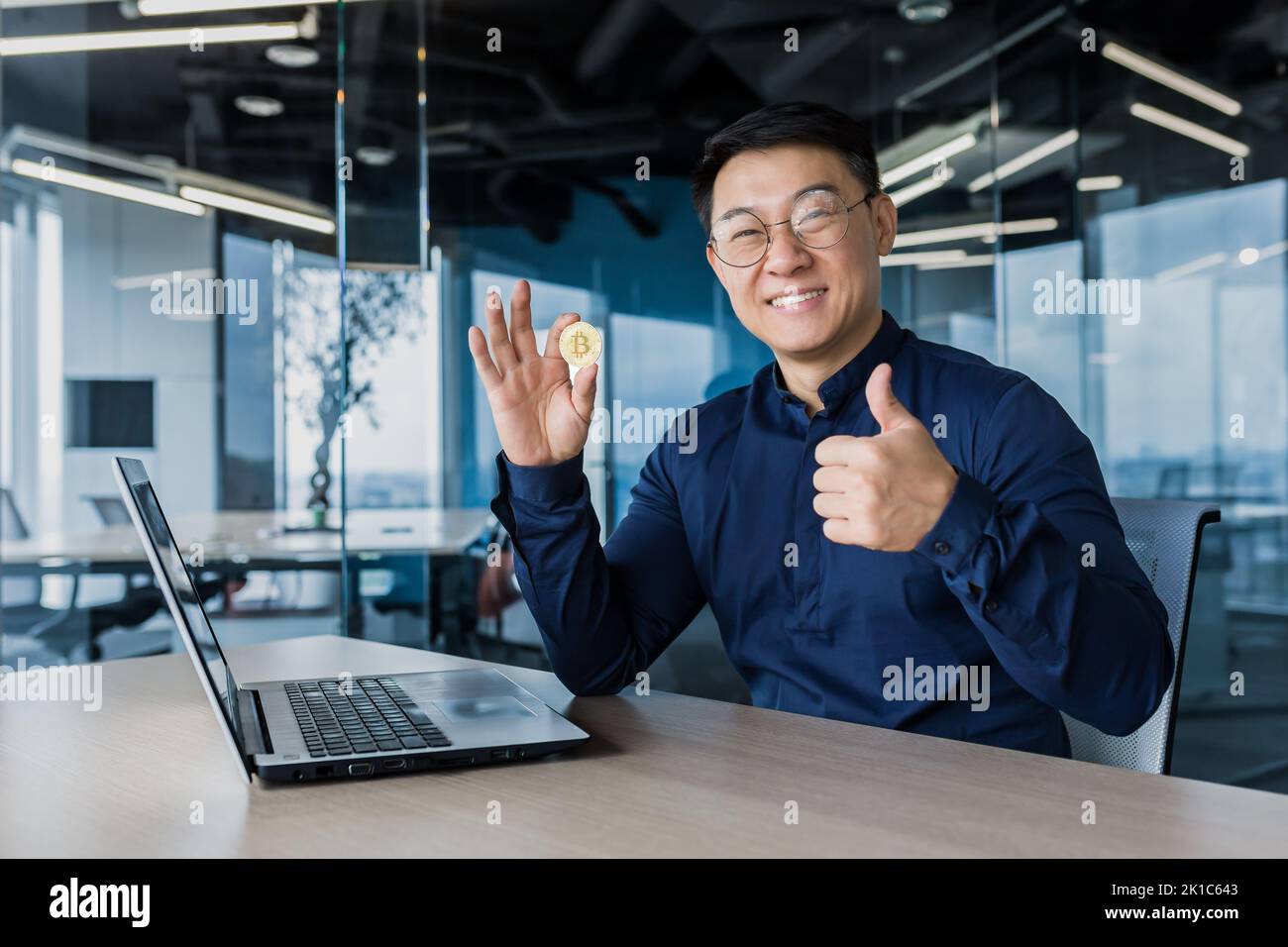 Successful asian businessman smiling and looking at camera, holding ...