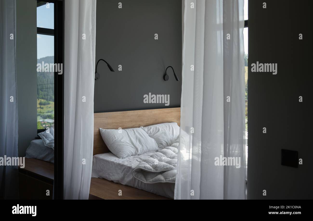 View of modern bed room behind white curtains with modern reading ...