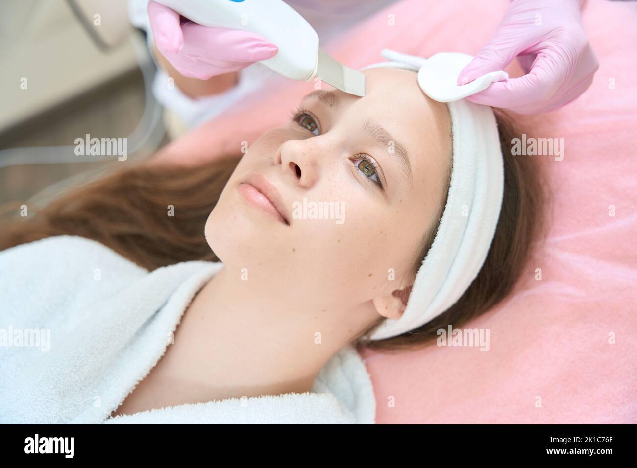 Dermatologist conducts ultrasonic cleaning with scrubber on face of ...