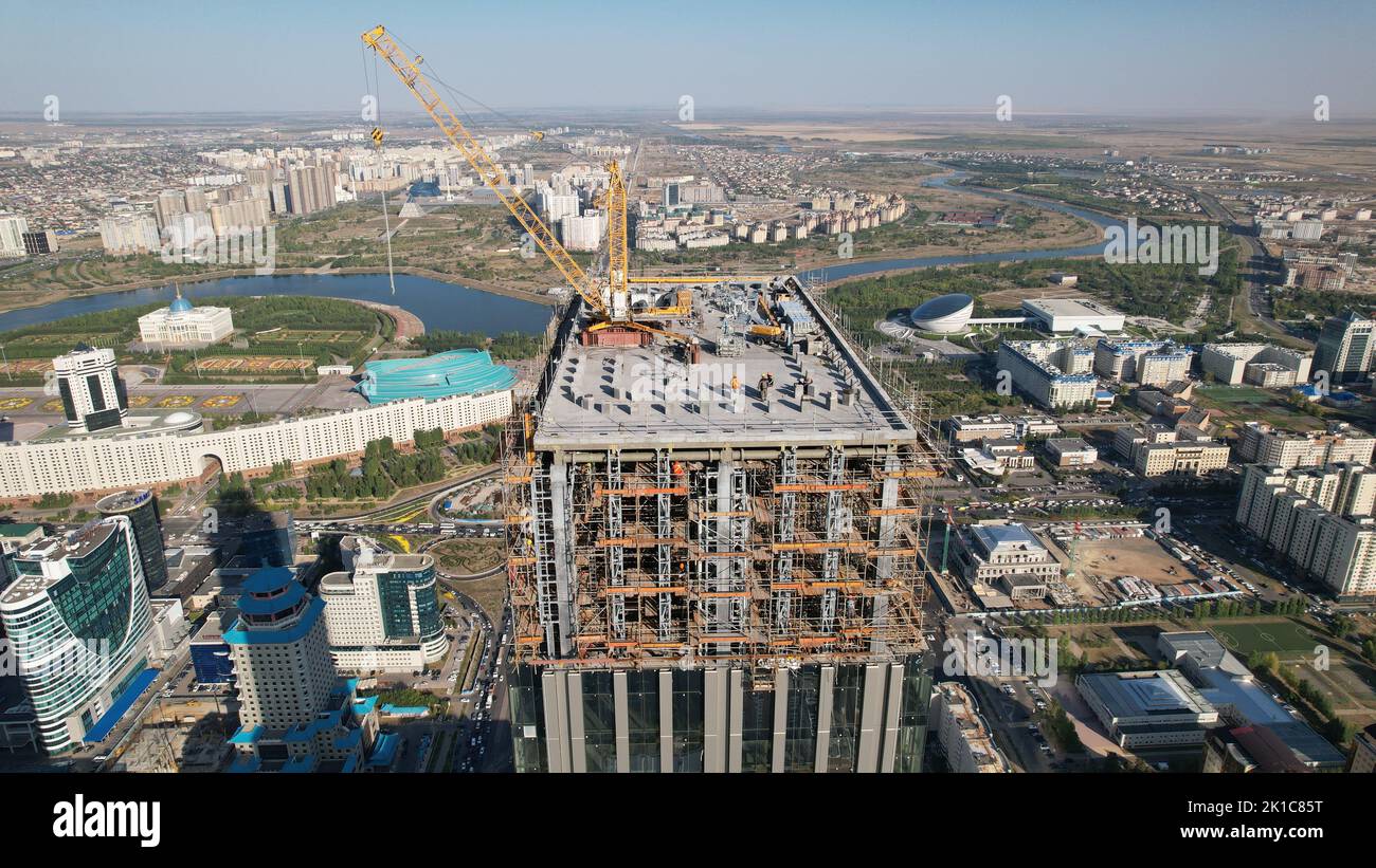 The aerial view of a crane over the skyscraper building -construction ...