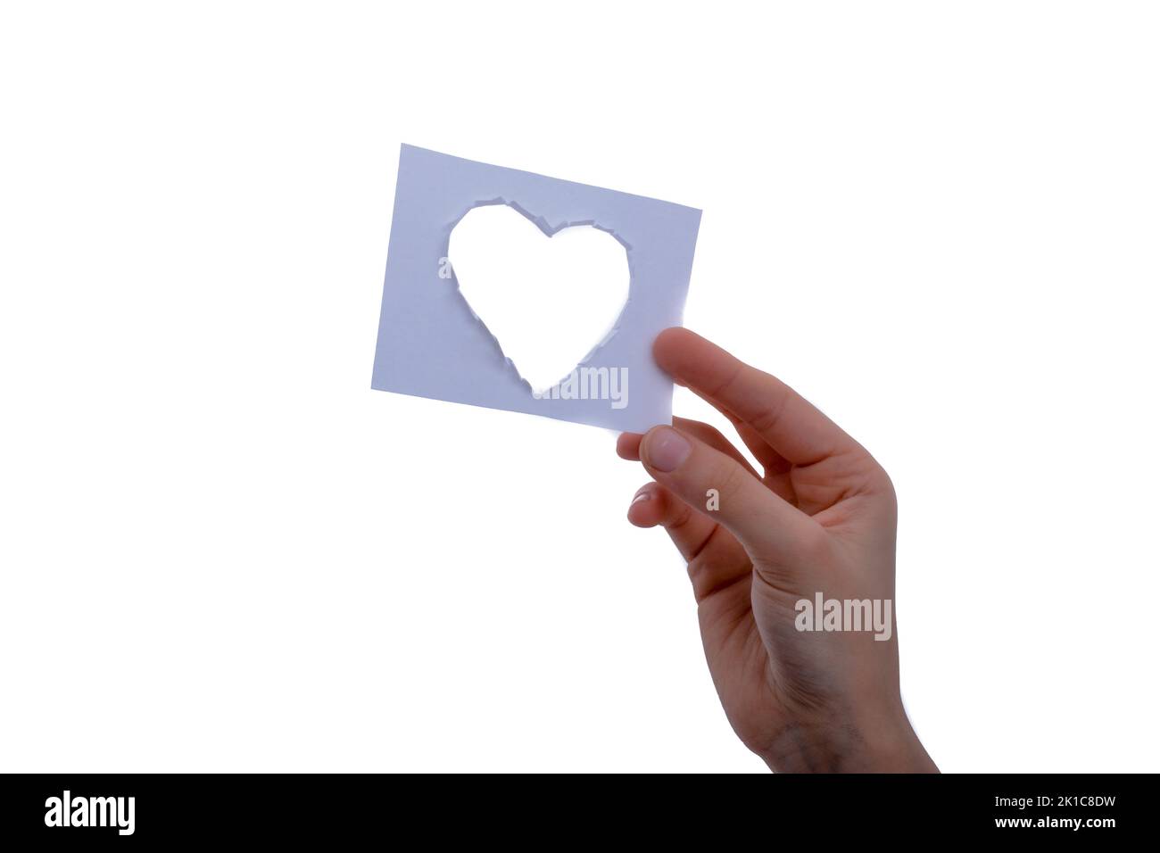 Hand holding a heart shape paper cut out of paper on a white background ...