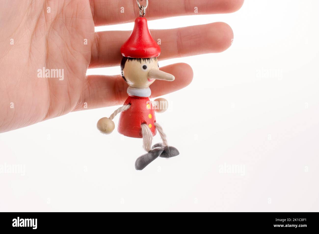 Pinocchio puppet in hand on a white background Stock Photo - Alamy