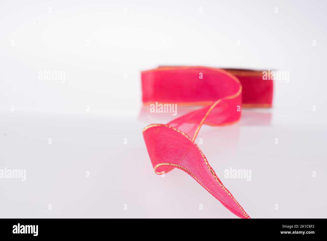 A roll of red ribbon, isolated on white Stock Photo - Alamy