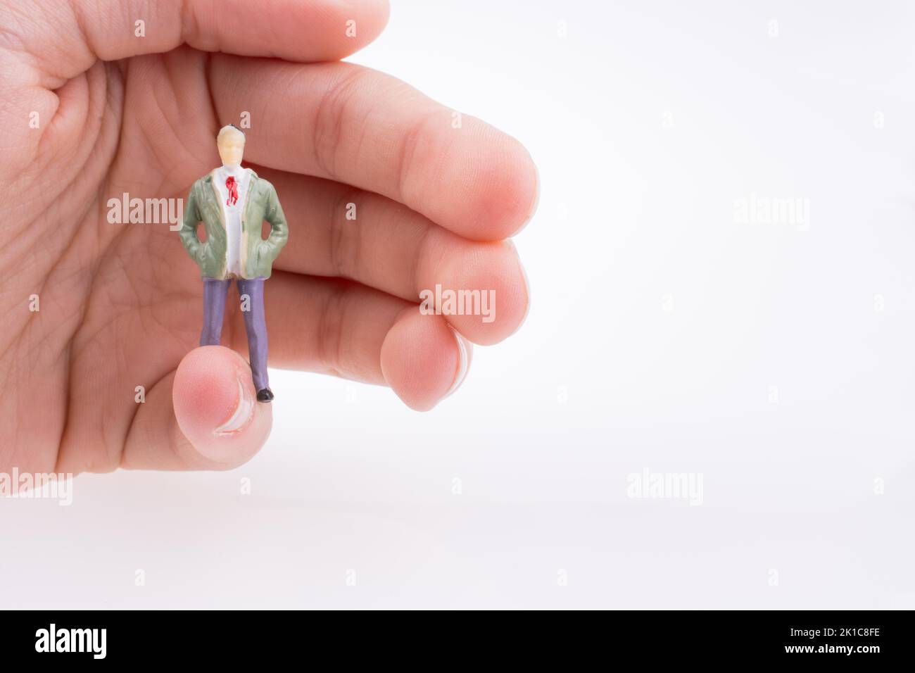 Hand holding a human figure on a white background Stock Photo - Alamy