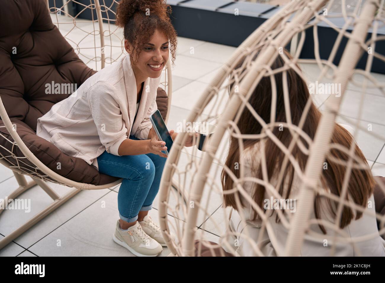 Two ladies sitting outdoors at coffee break Stock Photo - Alamy