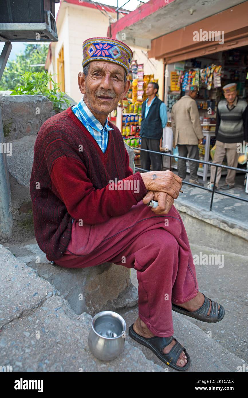 Indian man with traditional kullu in a residential area in Manali ...
