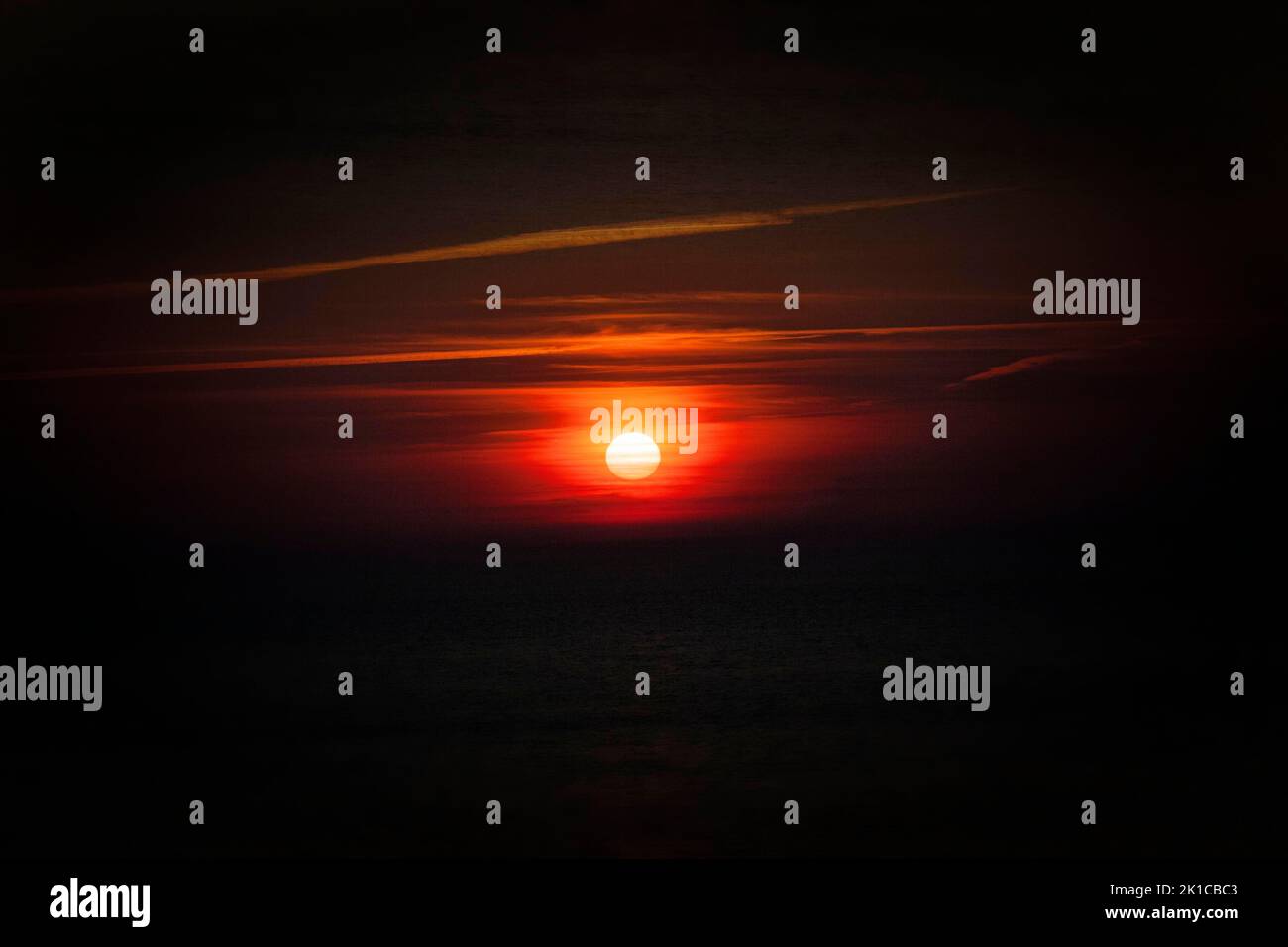 Sun shines through veil clouds, shines in the dark sky, sunrise, sunset ...