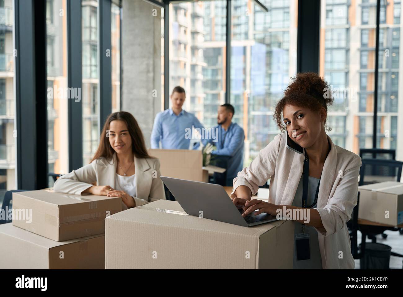 Pleased corporate employee and her coworkers conducting office move ...