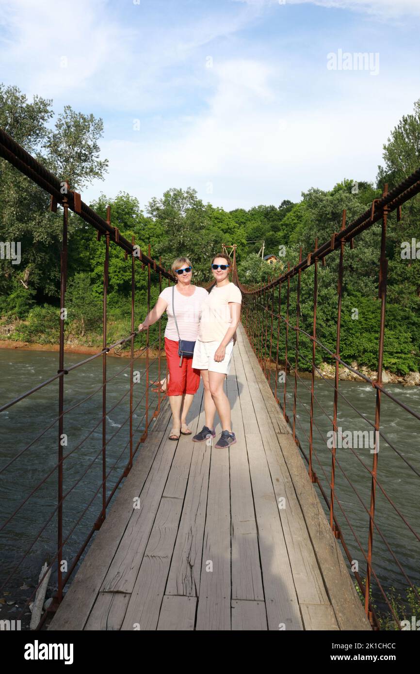 Two women on suspension bridge over Belaya River, Adygea Stock Photo ...